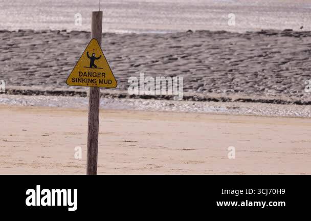 WESTON, UK - AUGUST 8, 2025 - Yellow triangular danger sinking mud sign ...