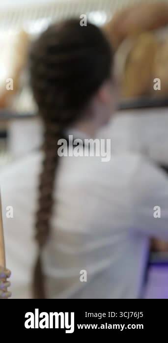 A joyful young woman baker beams as she carefully affixes price labels ...