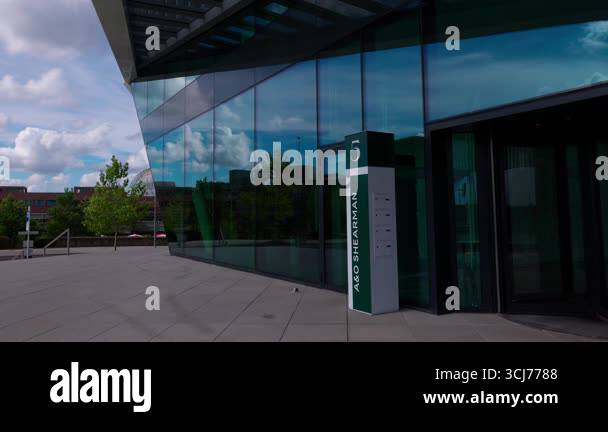 LUXEMBOURG, EUROPE - SEPTEMBER 1, 2025 - Modern glass building of Allen and Overy reflecting ...