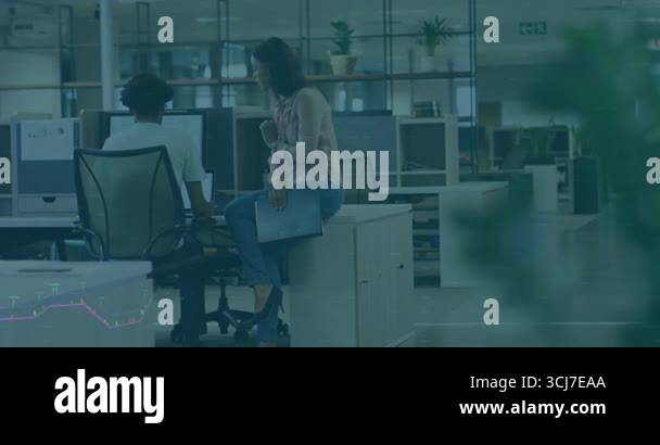 Woman ending phone call and turning to colleague pointing at monitor ...