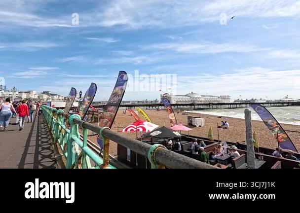 People walking on Brighton beach promenade Stock Video Footage - Alamy
