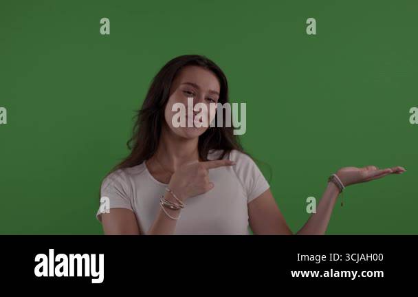 Young woman pointing her finger to her open hand showing something on ...