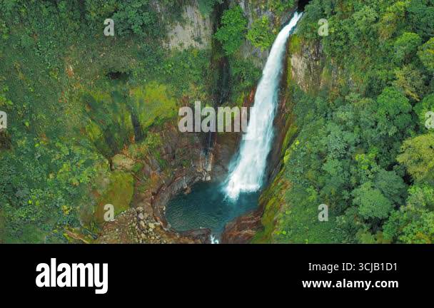 Powerful Blue Falls waterfall crashes into emerald pool amid jungle in ...
