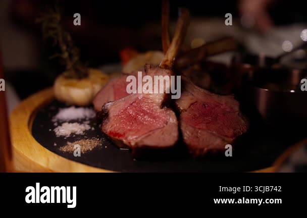 Close-up of succulent grilled lamb chops sizzling over an open flame ...