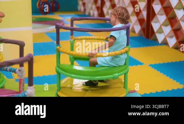 A young child enjoys playing on vibrant playground equipment in an ...