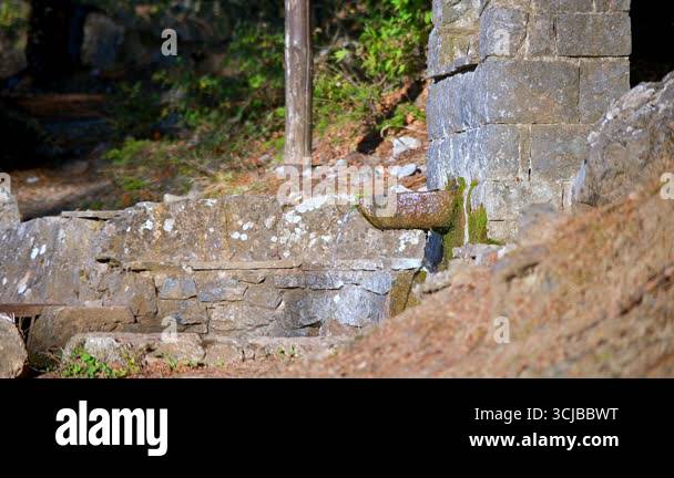 Static shot footage of an old stone spring with flowing water at a ...
