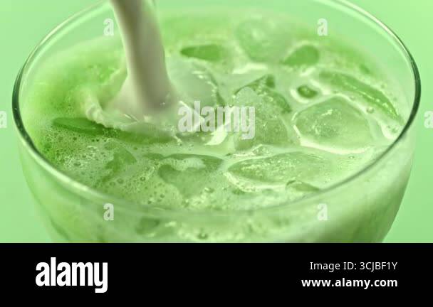 Super Slow Motion Detail Shot of Pouring Cream into Matcha Latte with ...