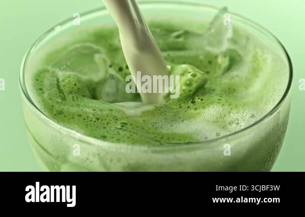 Super Slow Motion Detail Shot of Pouring Cream into Matcha Latte with ...