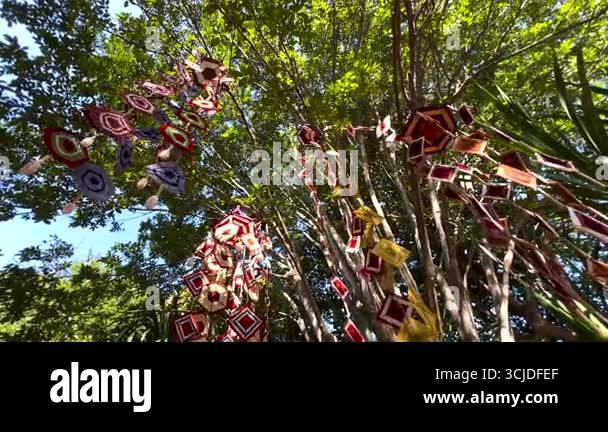 Vibrant mobiles sway among lush green trees Stock Video Footage - Alamy