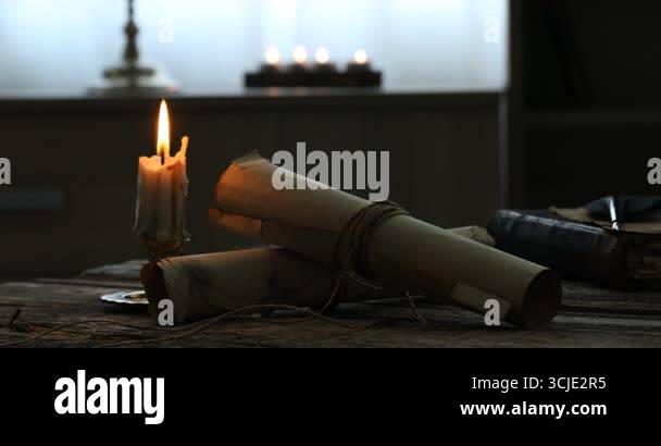 Old rolled scrolls and burning candle on wooden table, closeup Stock ...