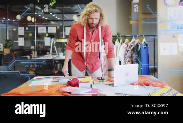 Male designer leaning forward and sorting fabric samples on table ...