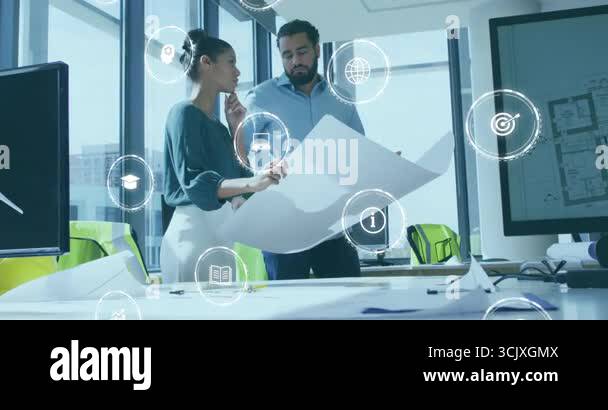 design team unrolling blueprint and examining plans in office with ...
