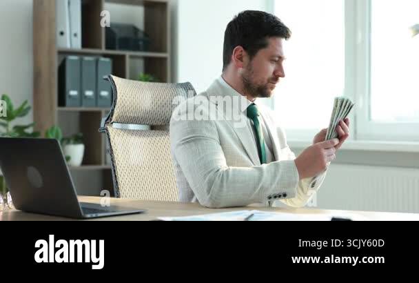 Greedy banker counting money and smiling at table in office Stock Video ...