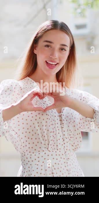 I love you. Caucasian woman makes symbol of love, showing heart sign to ...