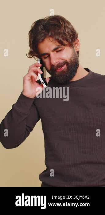 Disinterested young Indian man having annoyed boring talk on smartphone ...