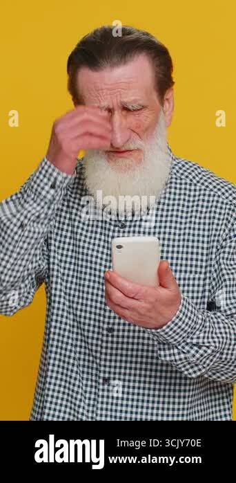 Upset sad senior man use smartphone typing browsing, play game, loses ...