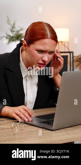 Young businesswoman at home office rubs tired eyes then puts on glasses ...