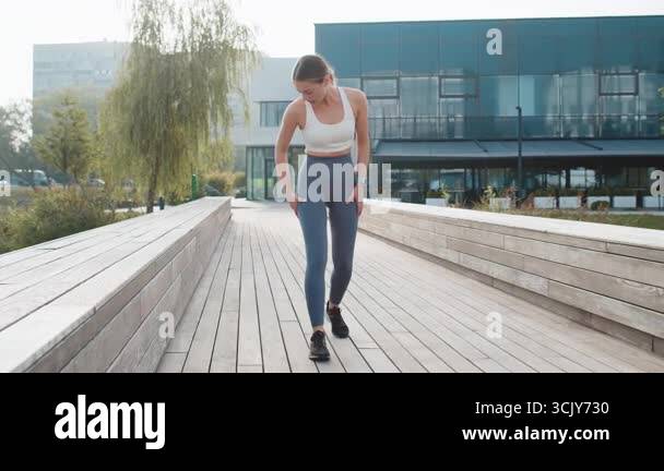 Athletic fit runner girl with muscle pain. Young woman massaging ...