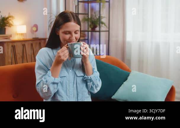 Lovely smiling happy Caucasian young woman drinking a cup of warm ...