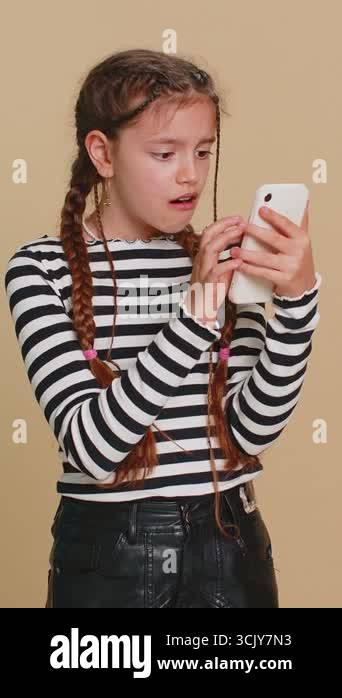 Upset sad preteen child girl kid use smartphone typing browsing, play ...