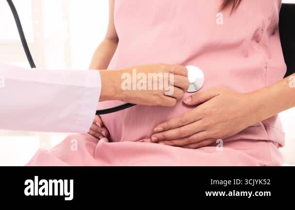 Senior doctor uses stethoscope to examine pregnant mother measure heart ...