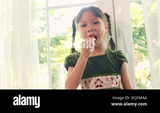 Portrait young girl with braids standing and eating sweets and chewing ...