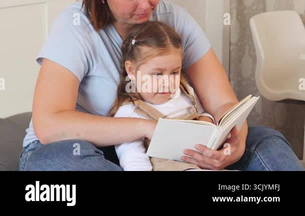 Small Caucasian child learns to read with help from a caregiver ...