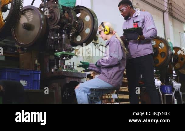 Male and female large machinery maintenance technicians work together ...