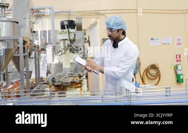 Large factory production line supervisor checks the production quality ...
