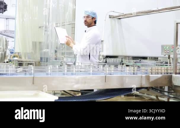 Large factory production line supervisor checks the production quality ...
