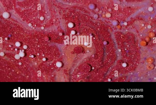 Ink particles. Paint water. Defocused red purple orange colorful ...