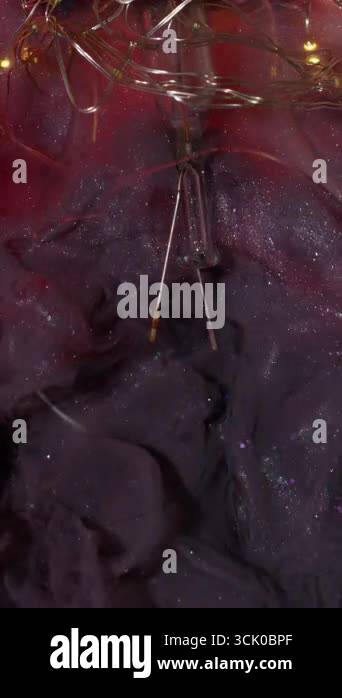 Vertical video. Shimmering flow. Paint haze. Expansion bright shiny red ...