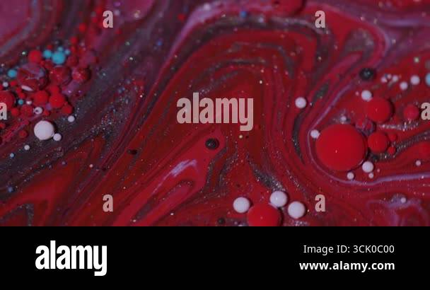 Drop flow. Color liquid. Defocused red pink purple sparkling ink water ...