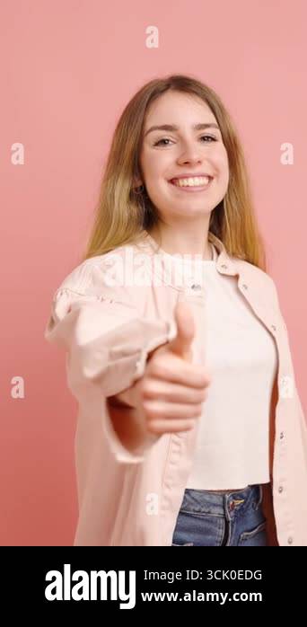 Young woman giving thumbs up, expressing positive approval with ...