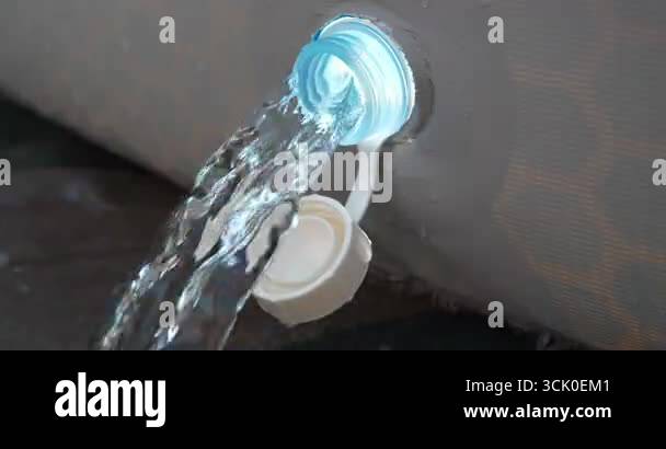 Water drains from a frame pool. Draining water from outdoor open-air ...