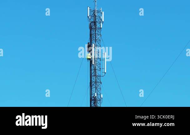 Two workmen on a cell tower. Maintenance staff at the work. High ...