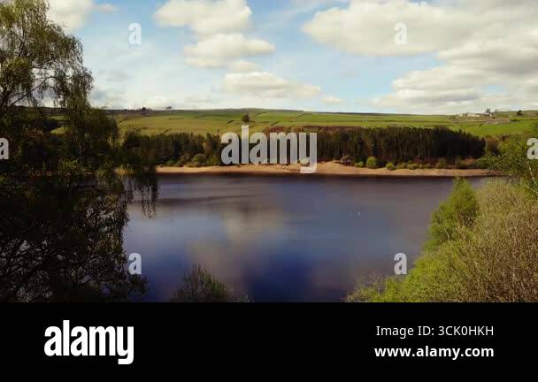Trees and farmland surround lake in Peak District National Park blue ...
