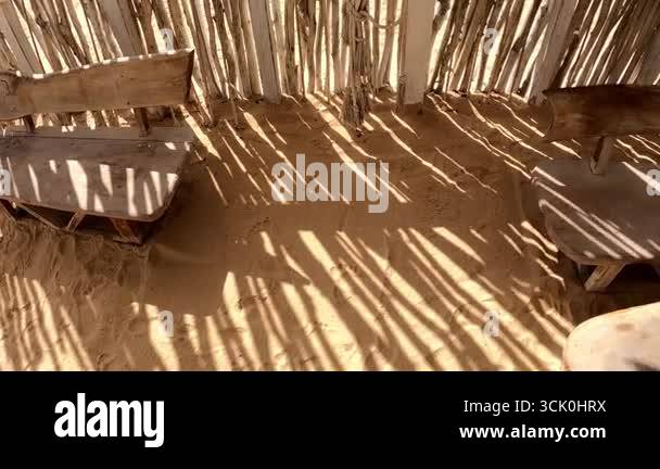 Wooden benches and fence casting shadows on sand Stock Video Footage ...