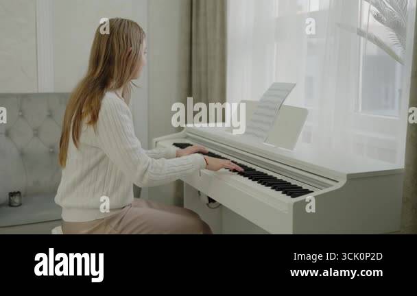 Teenage girl practicing piano at home. Study and learning development concept. Focused young ...