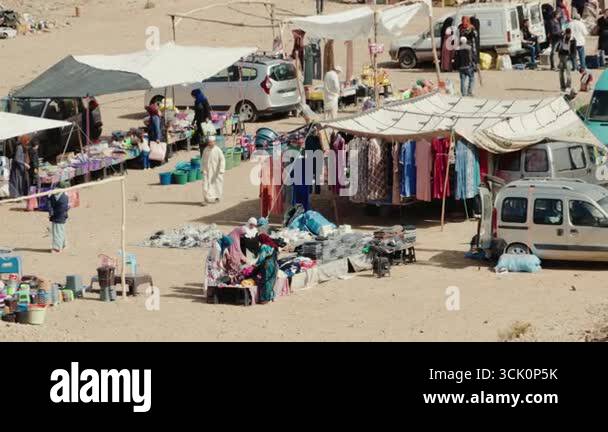A bustling Moroccan desert market comes alive with vibrant colors and ...