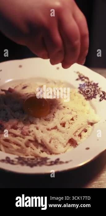 Vertical video. Cooking carbonara. Tasty macaroni. Chef hand adding ...