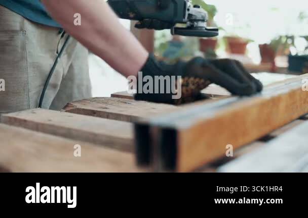 A worker is grinding rust off a steel part with an angle grinder. Close ...