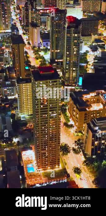 Glowing night streets of Honolulu on the island of Oahu. Tall hotel ...