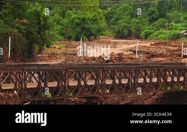 Damaged bridge with debris after flood disaster in rural mountain area ...
