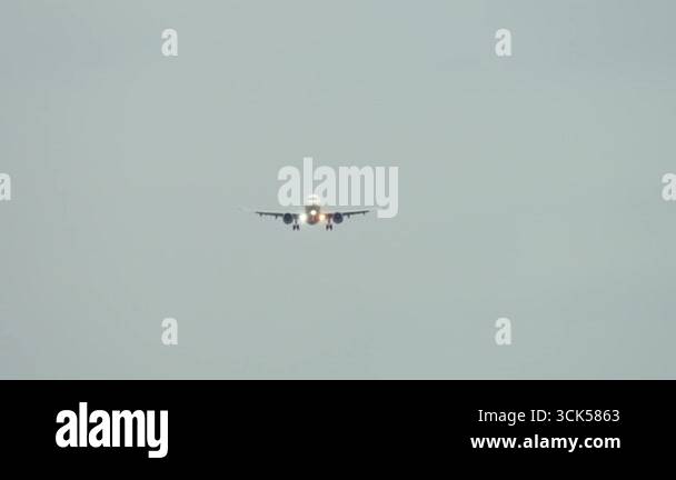 Airplane flying in foggy weather with landing gear down and lights on ...