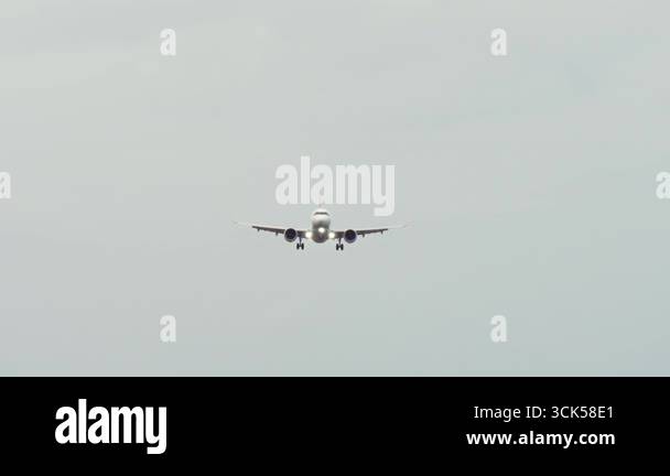Passenger plane slowly approaching runway in cloudy weather. Aircraft ...