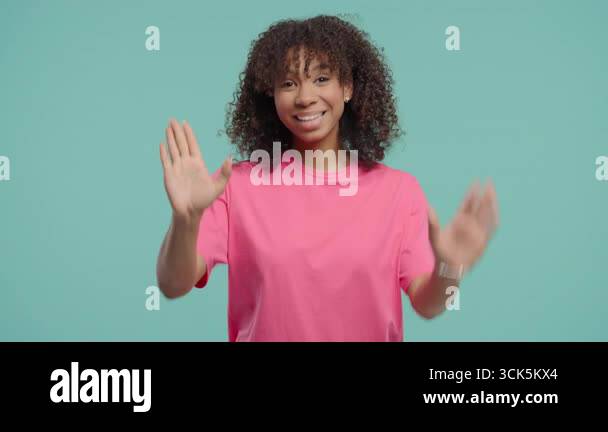 Friendly young african american woman waving hand - hello, or salute ...