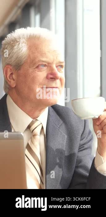 A distinguished senior Caucasian businessman, dressed in a sharp suit ...