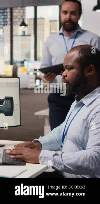 Manager overseeing engineer using CAD app to optimize wind turbine design, reducing carbon ...