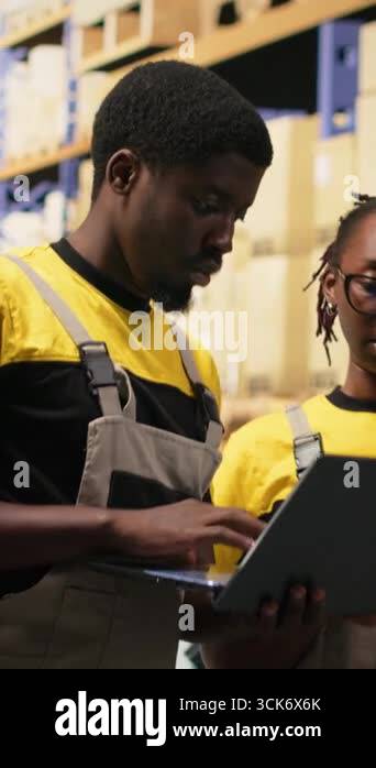Vertical Video Warehouse workers overseeing parcels tracking info on ...